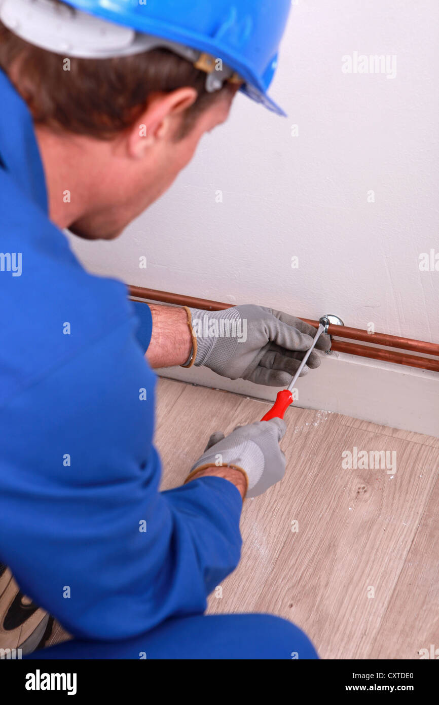 Artisan fixing copper tubes Stock Photo - Alamy