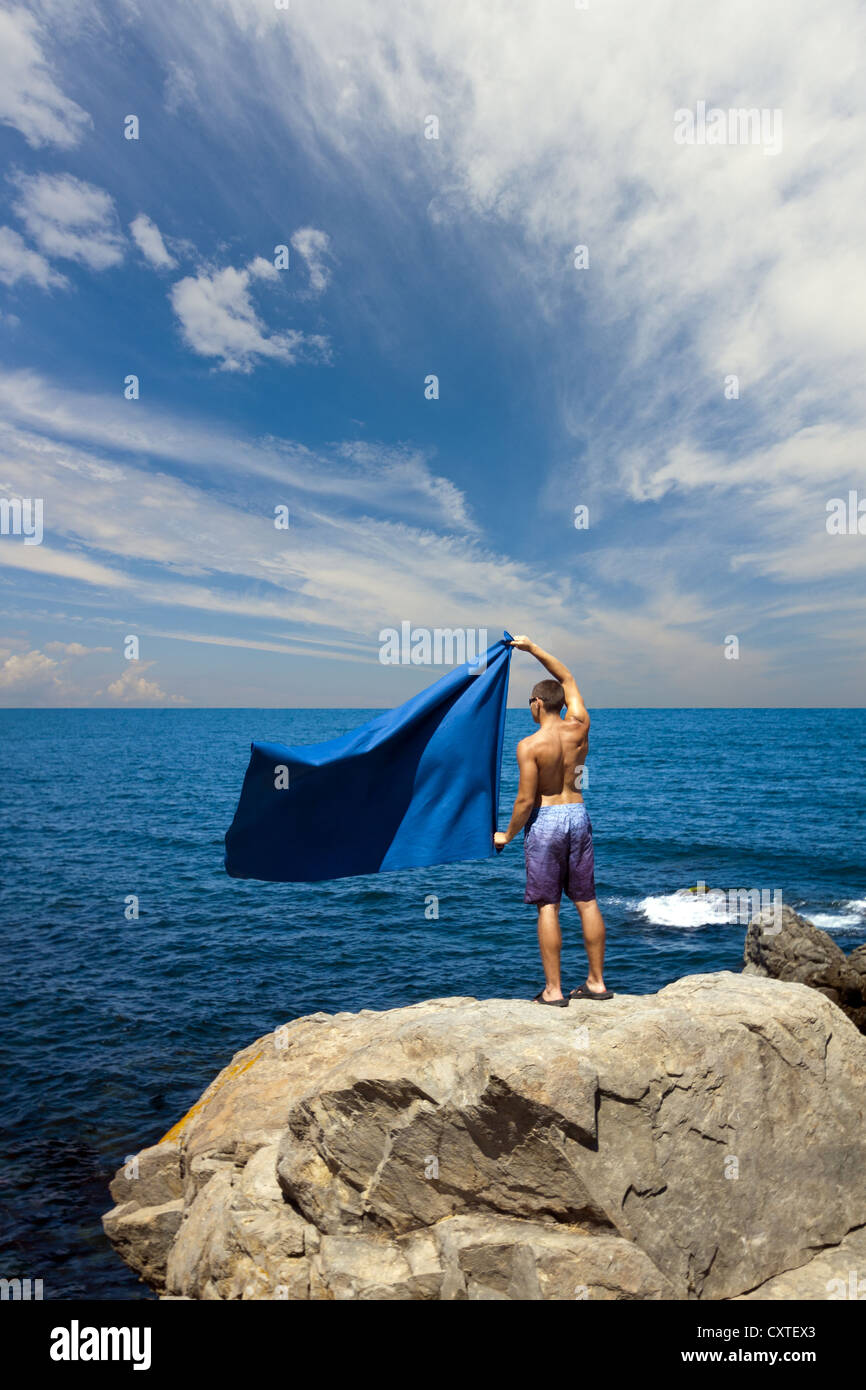 the man who holds the blue blanket moving in the wind Stock Photo - Alamy