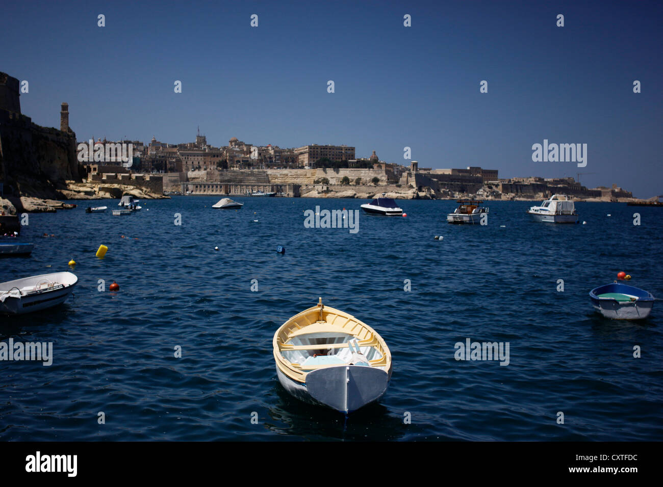 A boat floats anchored in front of Valletta city, capital of Malta ...