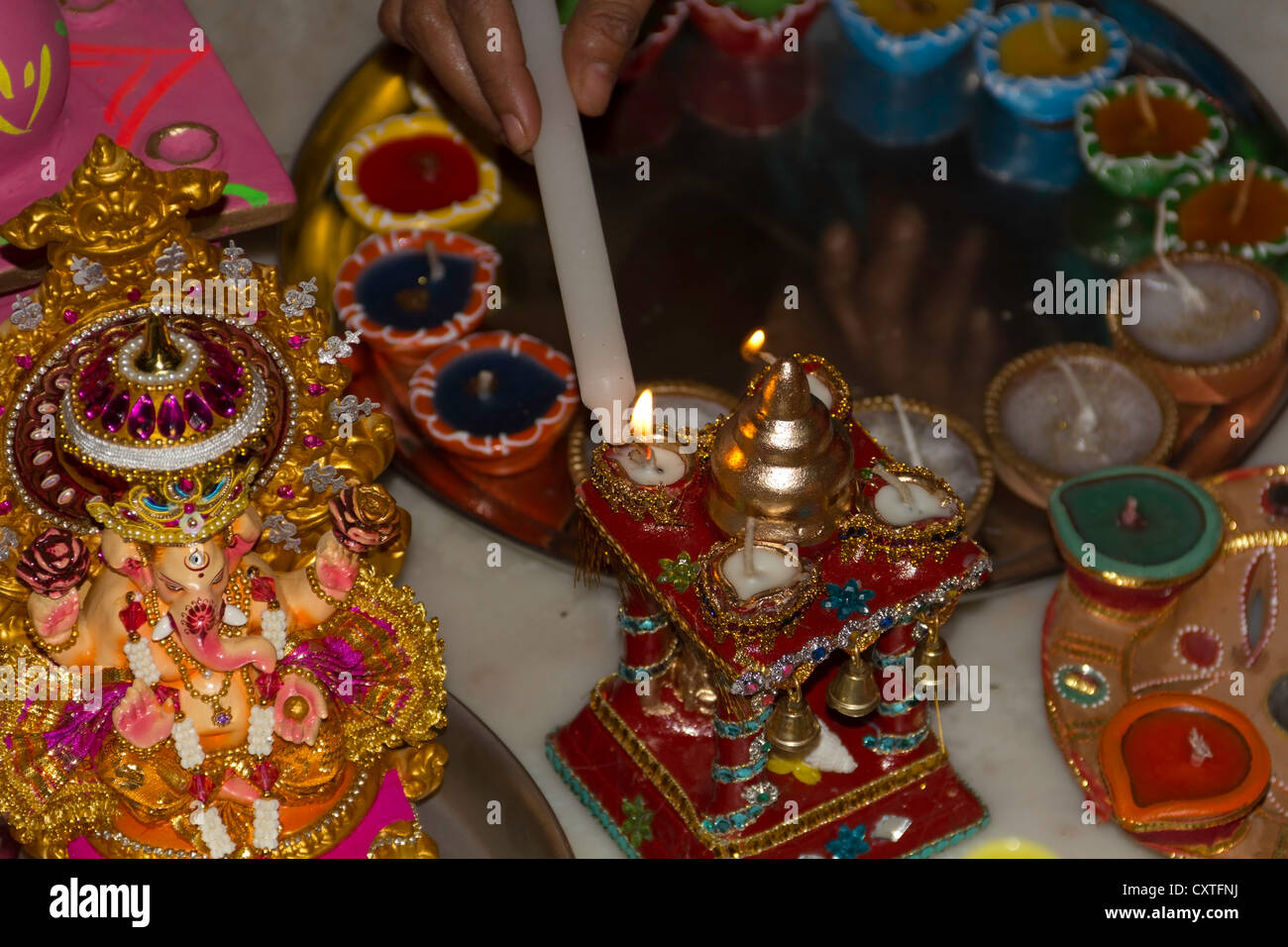 Lighting a very colorful lamp as part of Diwali prayers. As part of the ...