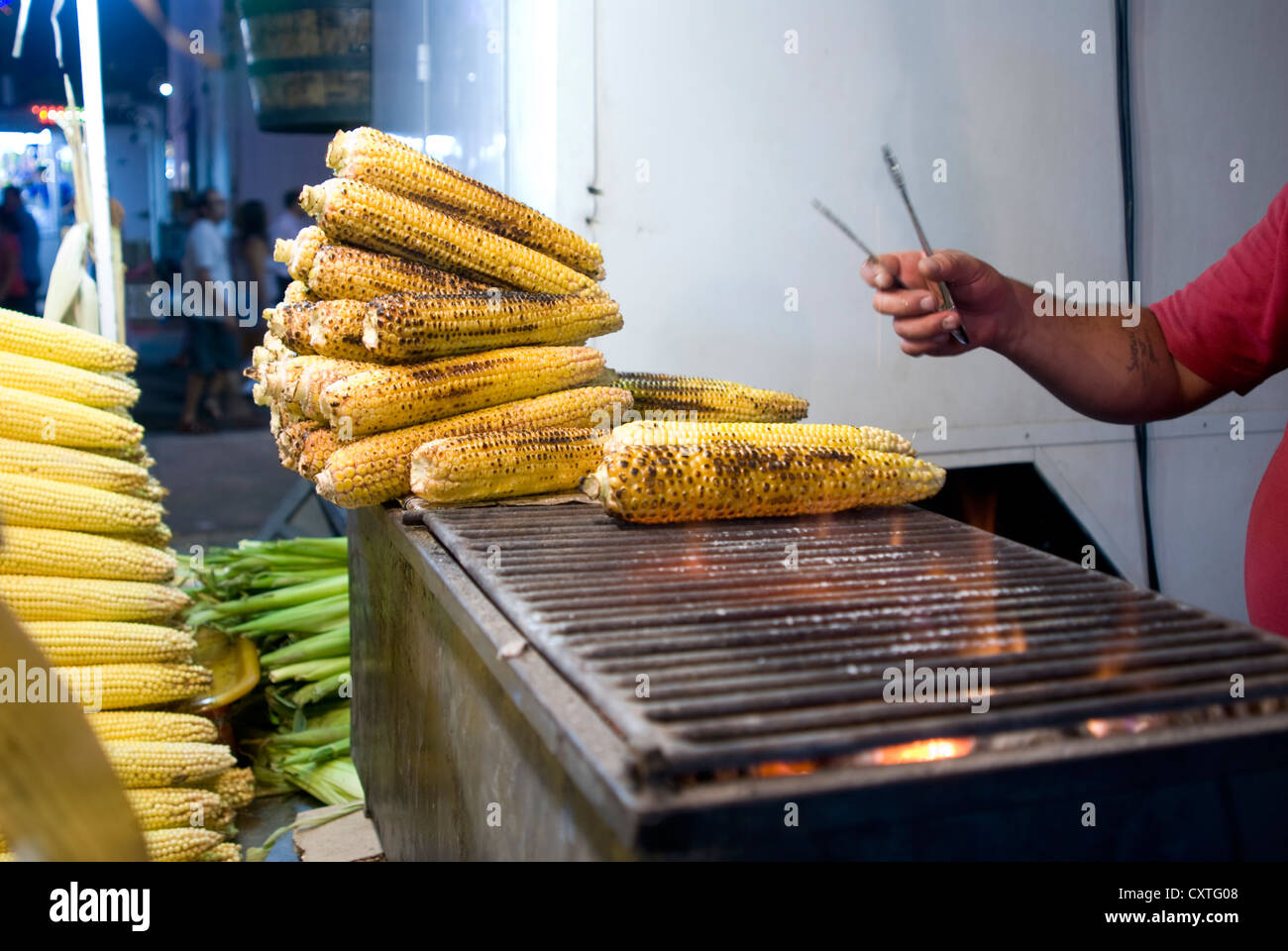 A food vendor charcoal grilling ears of sweetcorn at the Maria Del Mar ...