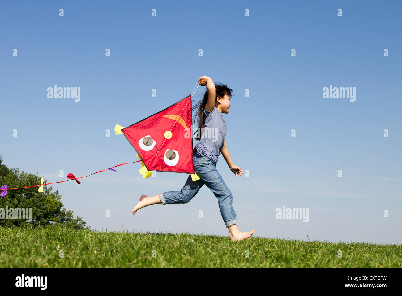 Girl playing with kite outdoors Stock Photo - Alamy