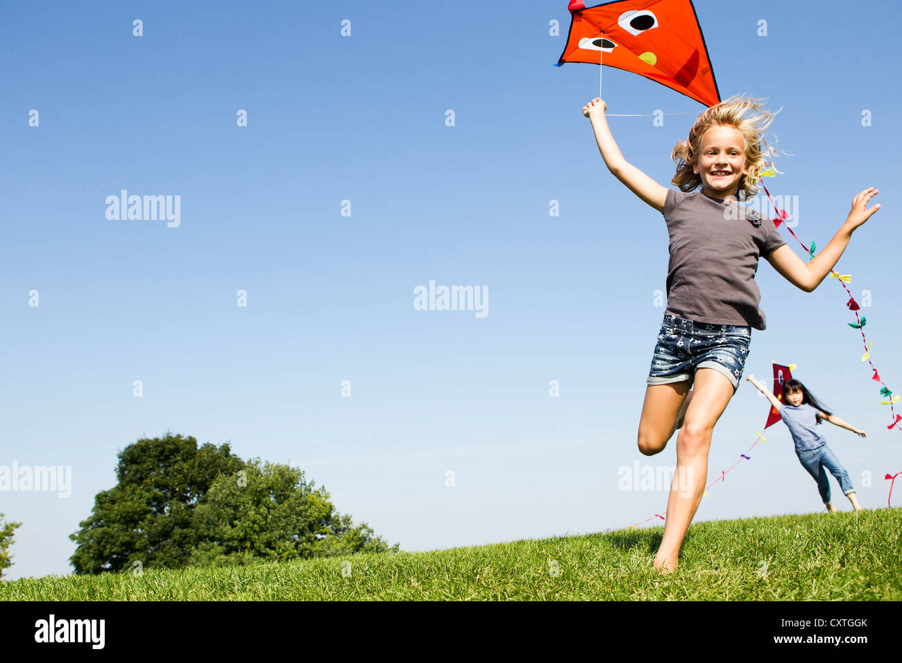 Girls playing with kites outdoors Stock Photo - Alamy