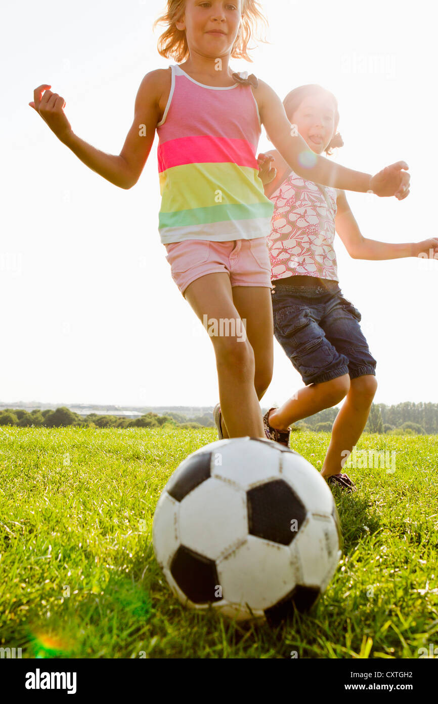 Girls playing soccer in field Stock Photo - Alamy