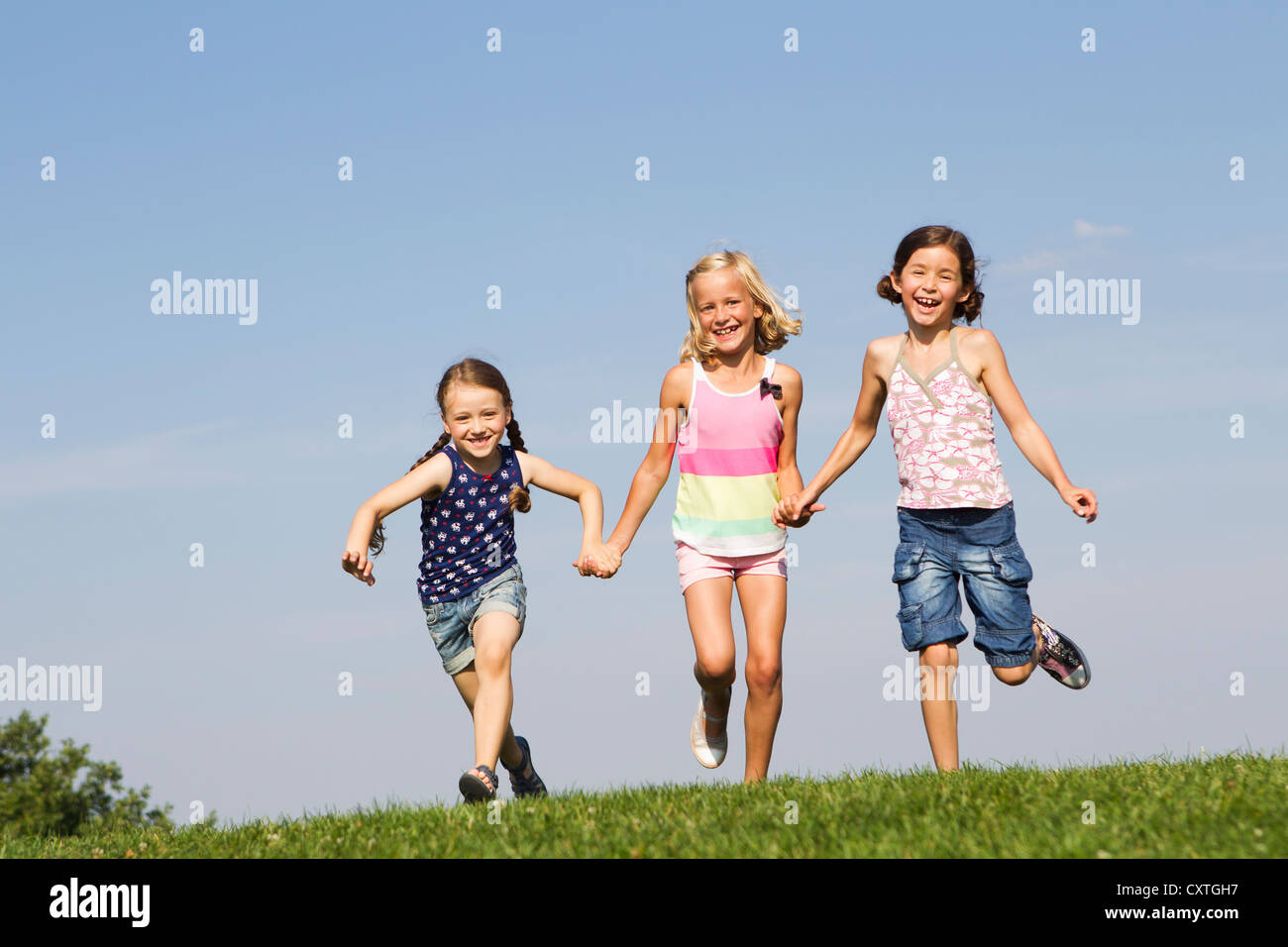 Girls running together in field Stock Photo - Alamy