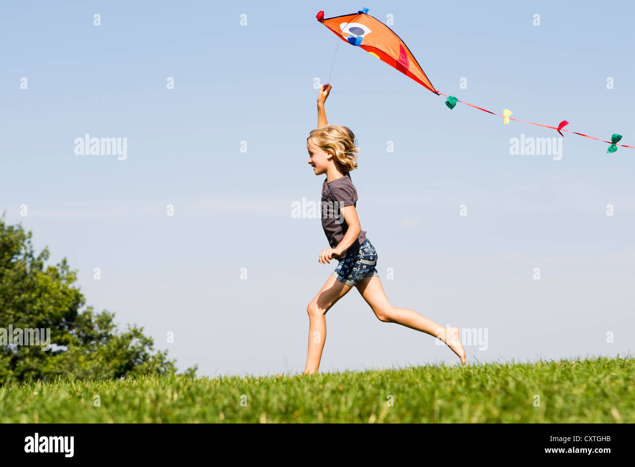 Girl playing with kite outdoors Stock Photo - Alamy