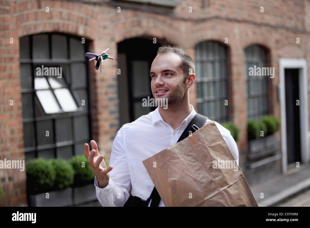 Businessman tossing keys in air Stock Photo - Alamy