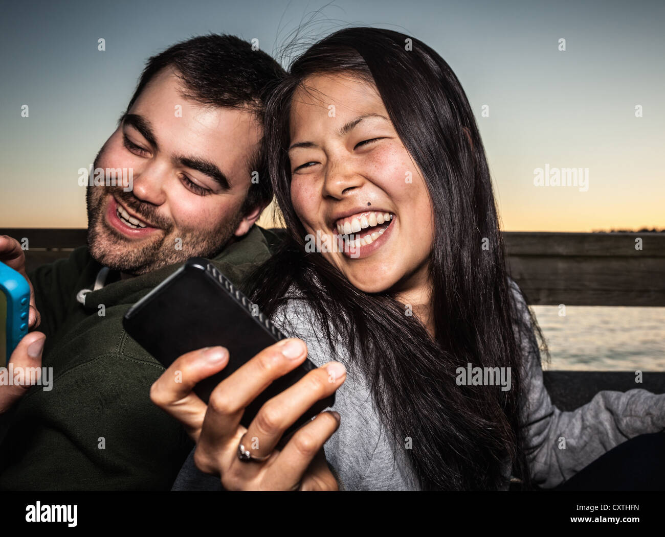 Couple using cell phones outdoors Stock Photo - Alamy