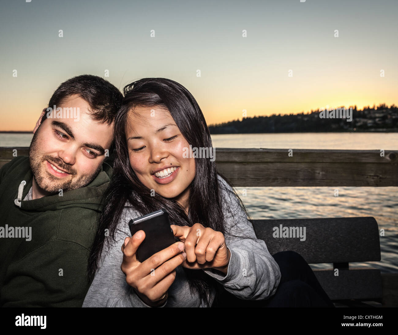 Couple using cell phone outdoors Stock Photo - Alamy