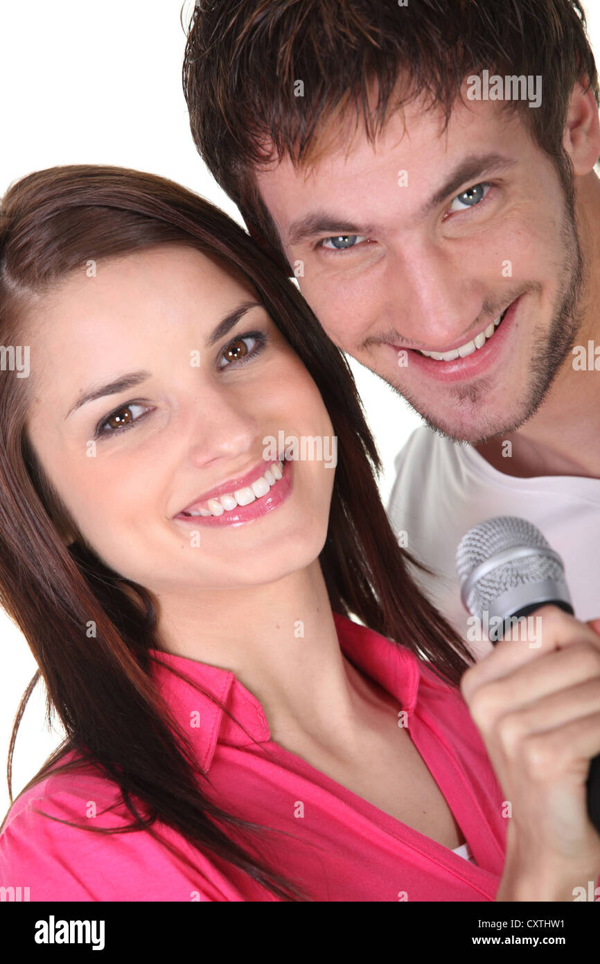 Couple singing into a microphone Stock Photo - Alamy