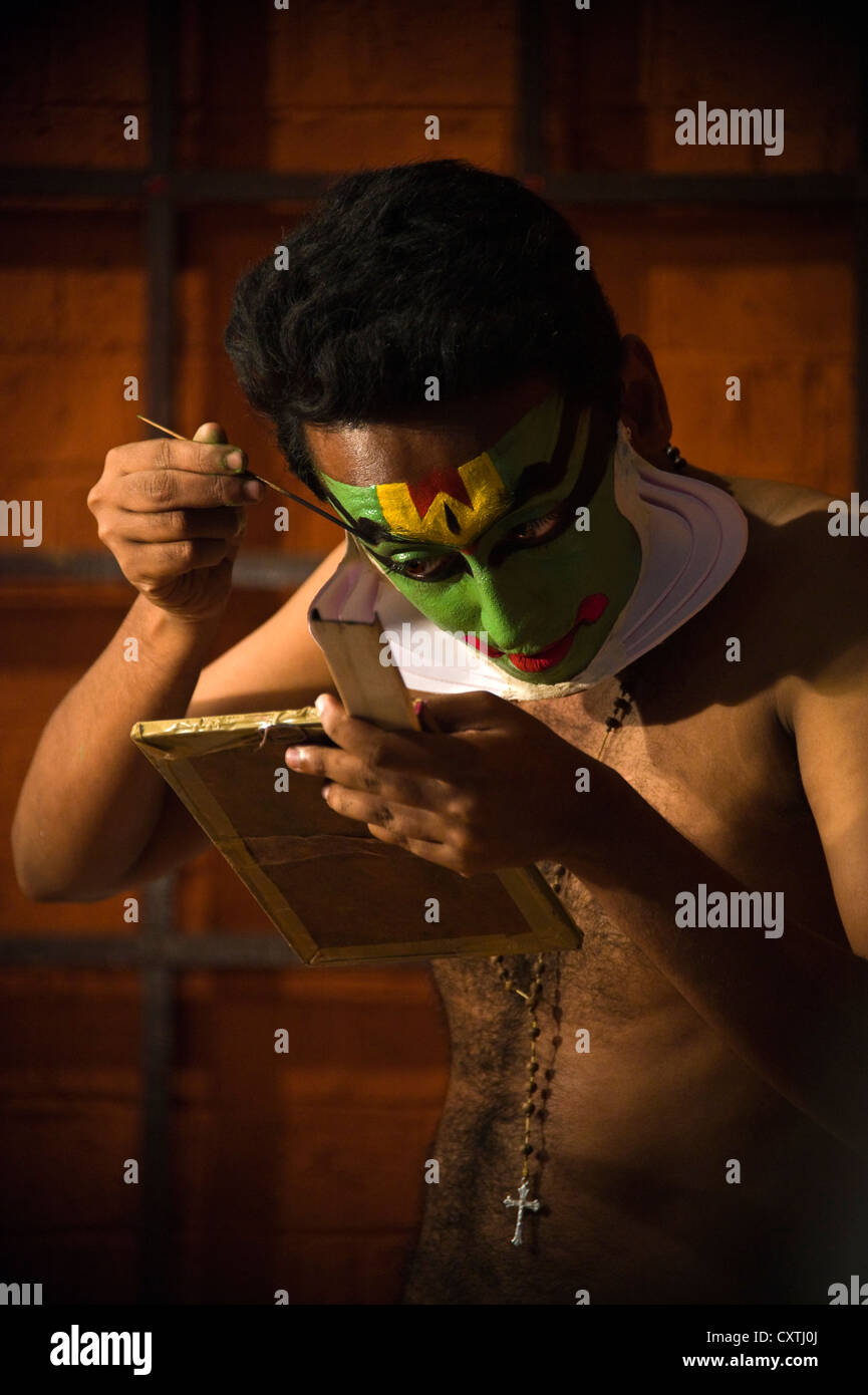 Vertical close up portrait of a Kathakali performance artist putting on ... Vertical close up portrait of a Kathakali performance artist putting on ...