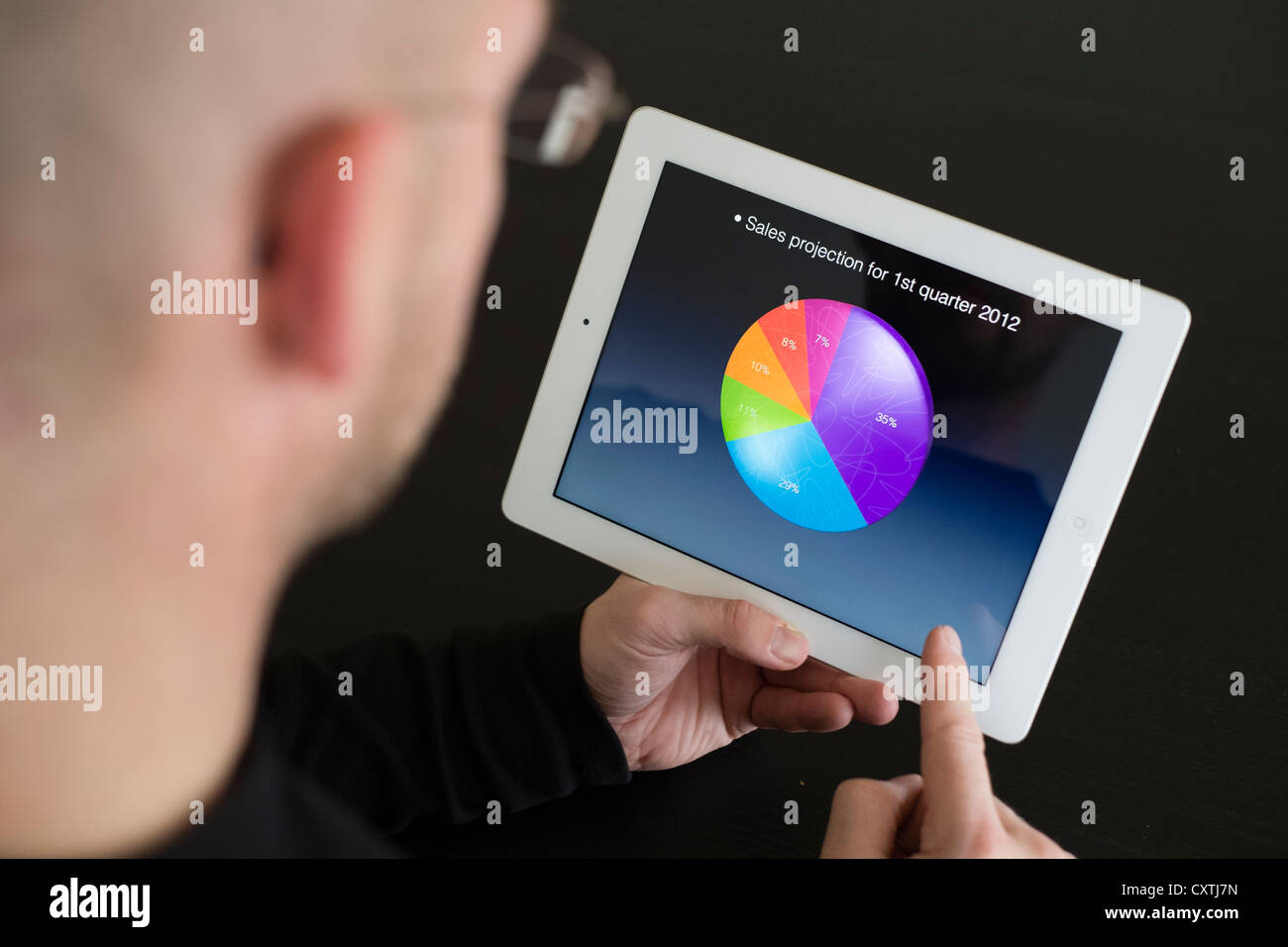 Man preparing business presentation with charts on iPad 3 tablet ...