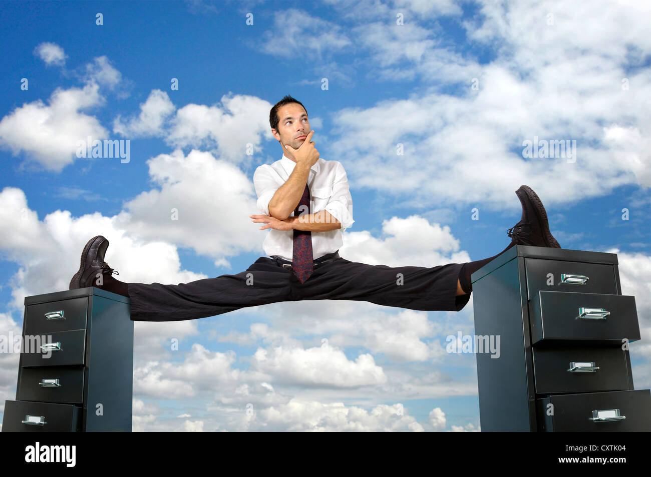Businessman doing splits over cabinet files Stock Photo - Alamy