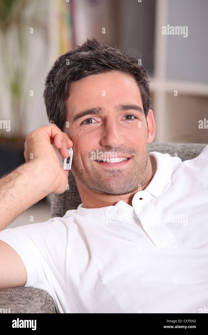Man sat on his sofa making a phone call Stock Photo - Alamy