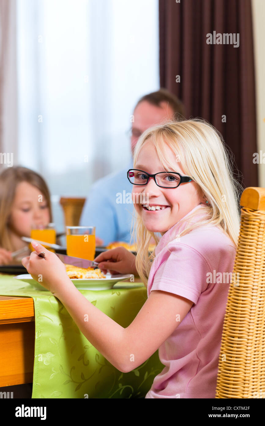 Family eating lunch or dinner and sitting at the table Stock Photo - Alamy
