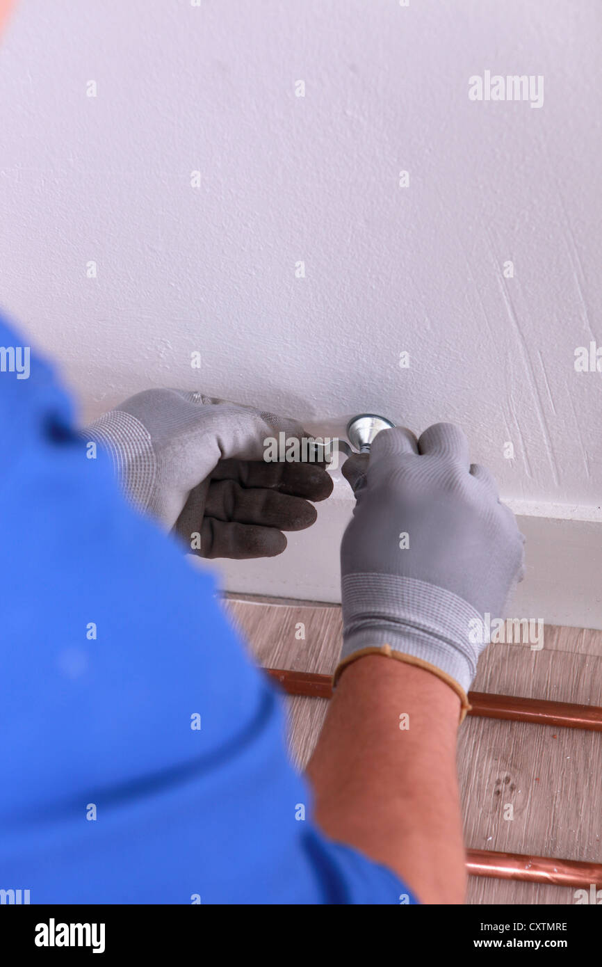 Plumber fixing copper pipe wall Stock Photo - Alamy