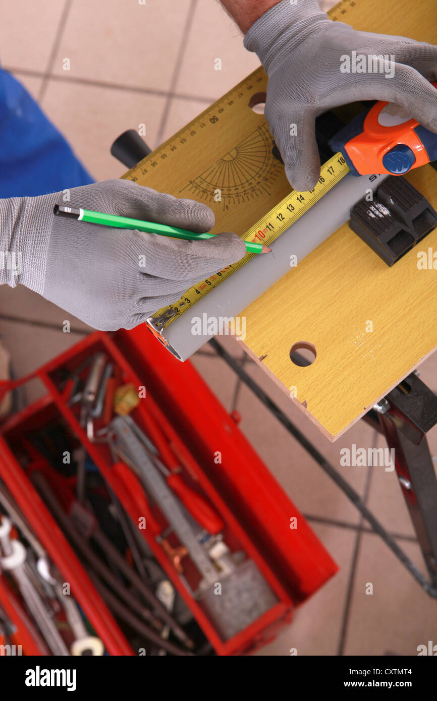 Plumber measuring plastic pipe Stock Photo - Alamy