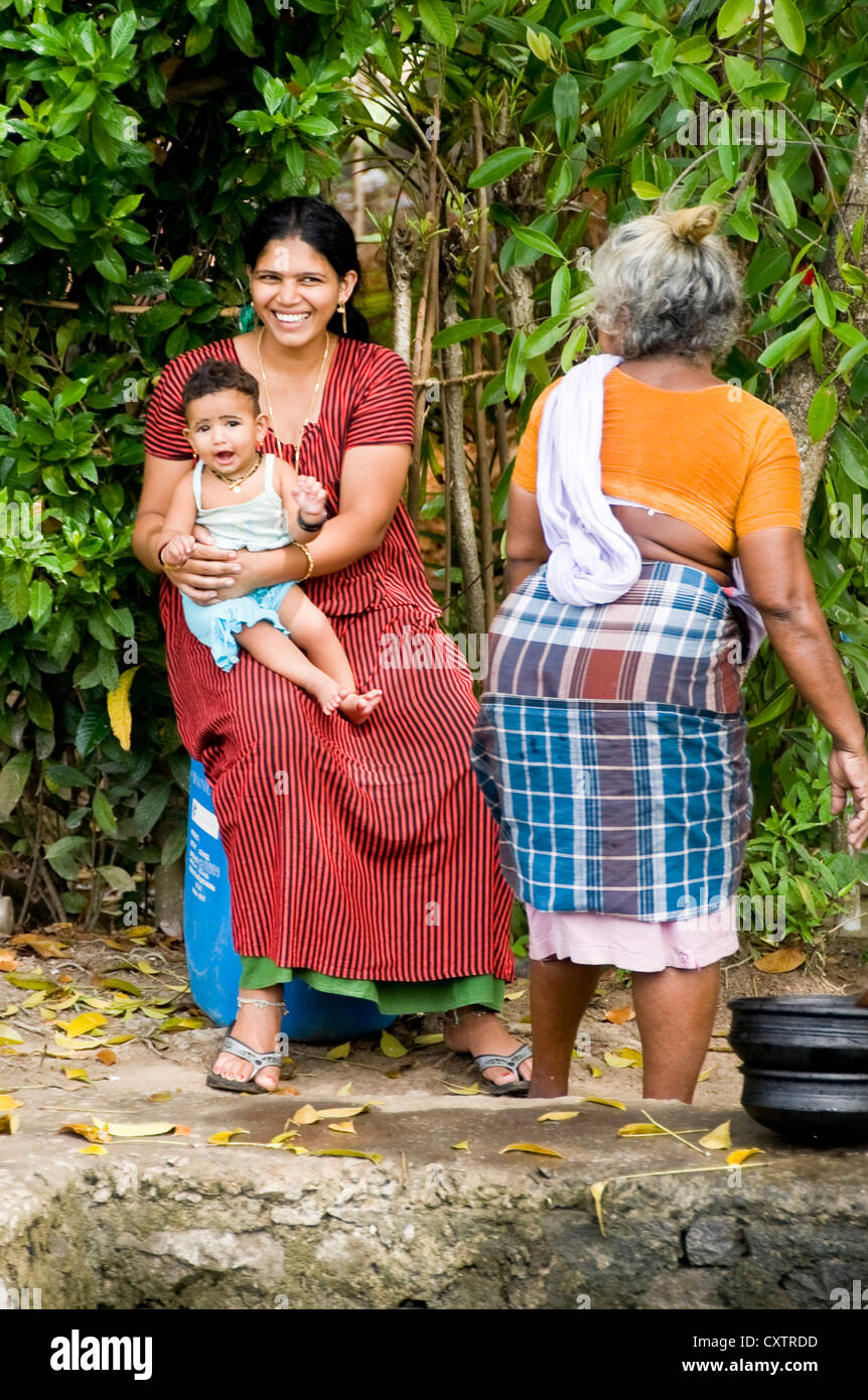 Vertical portrait of three generations of an Indian family doing their ...