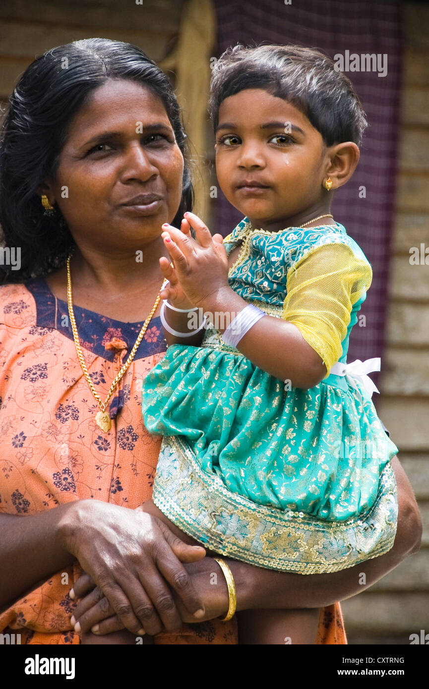 Vertical portrait of an Indian woman holding her daughter by the ...