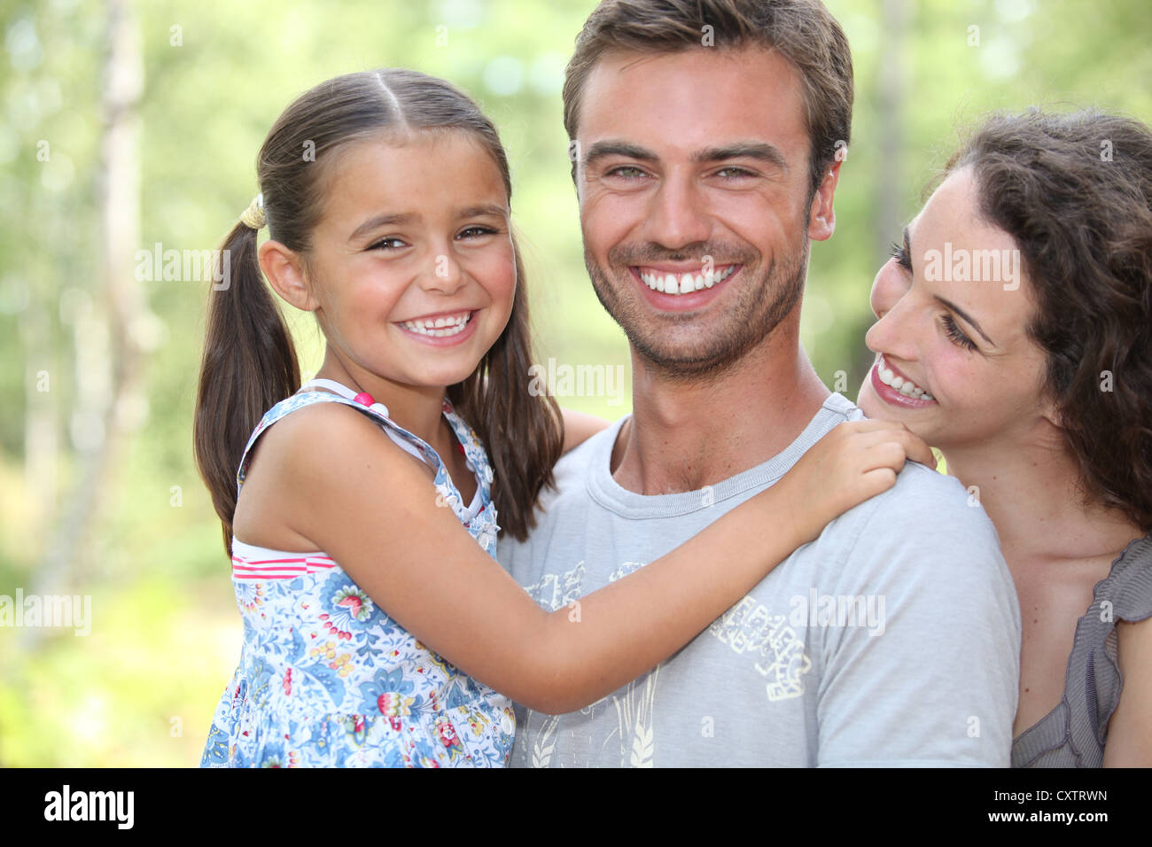 Young family stood in garden Stock Photo - Alamy