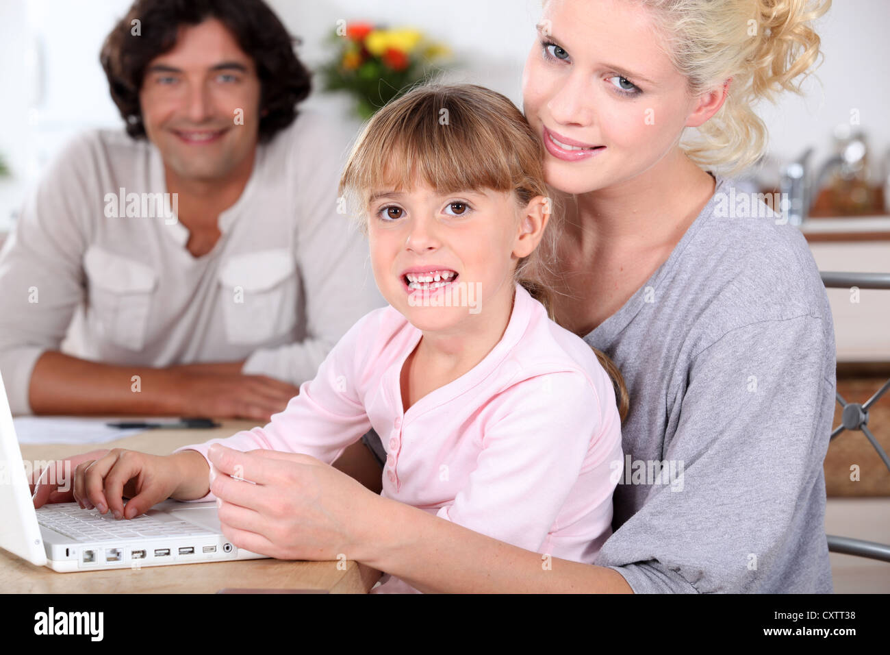 Parents and daughter using a laptop computer Stock Photo - Alamy
