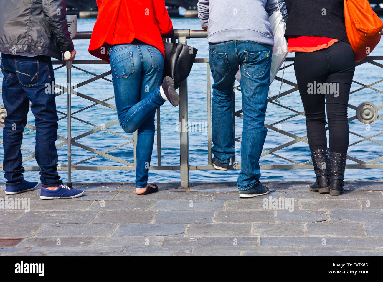 Four people leaning on a railing in Geneva, Switzerland Stock Photo - Alamy