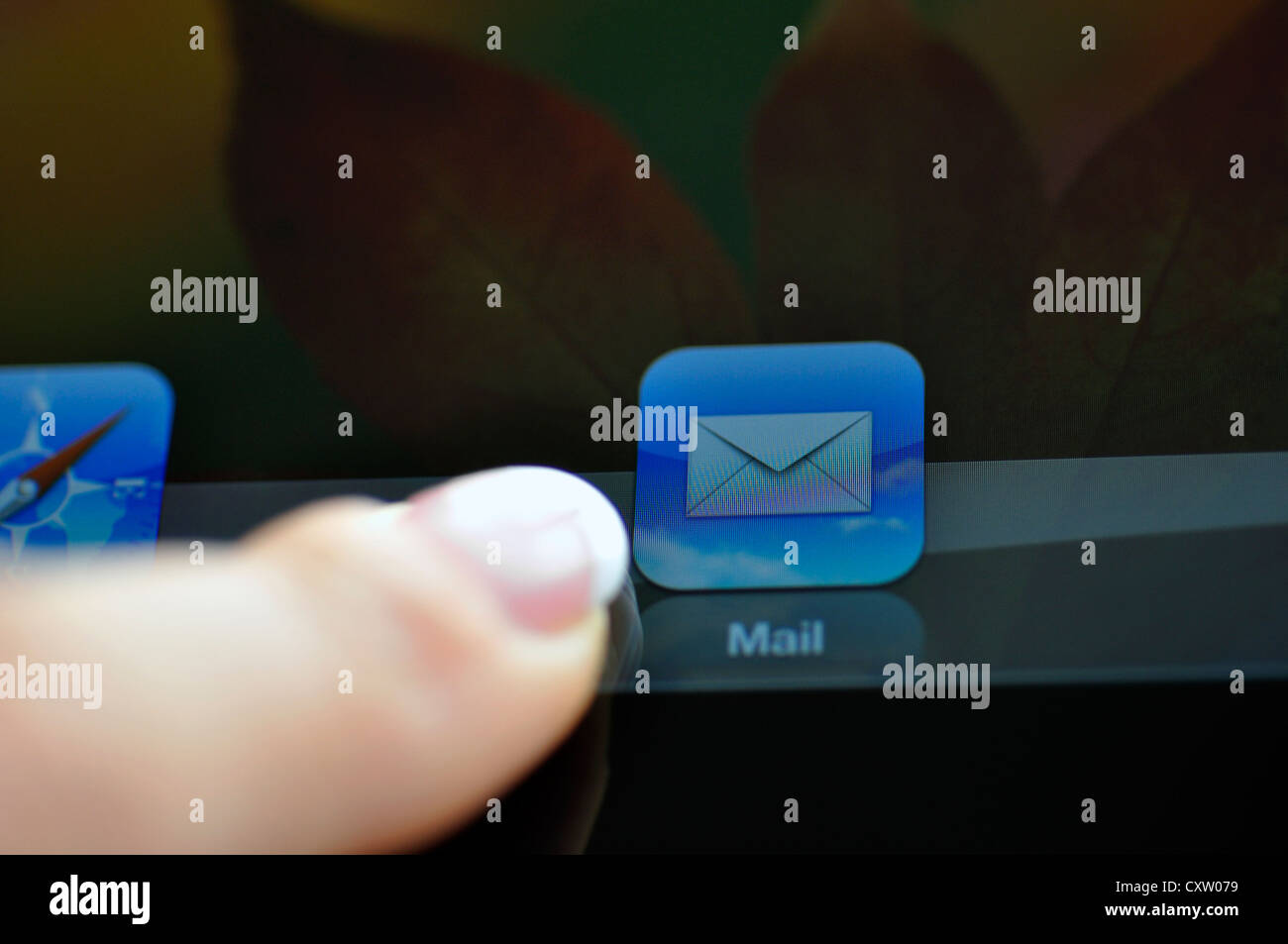 Mail icon for iPad and finger pressing it Stock Photo - Alamy