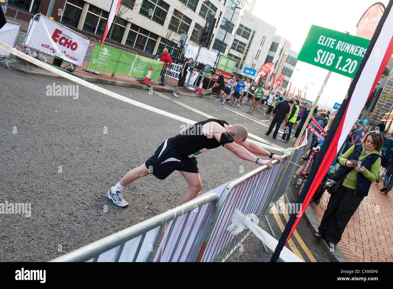 A runner stretches before the start of a half marathon Stock Photo - Alamy