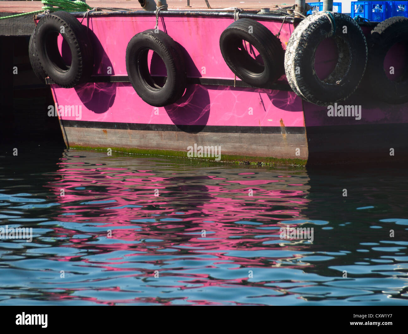 Pink stern of boat reflecting in the blue waters of the Marmara sea ...