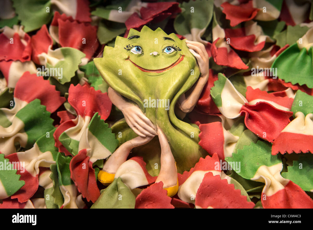 A shop window display with a young woman fashioned from pasta lying on ...