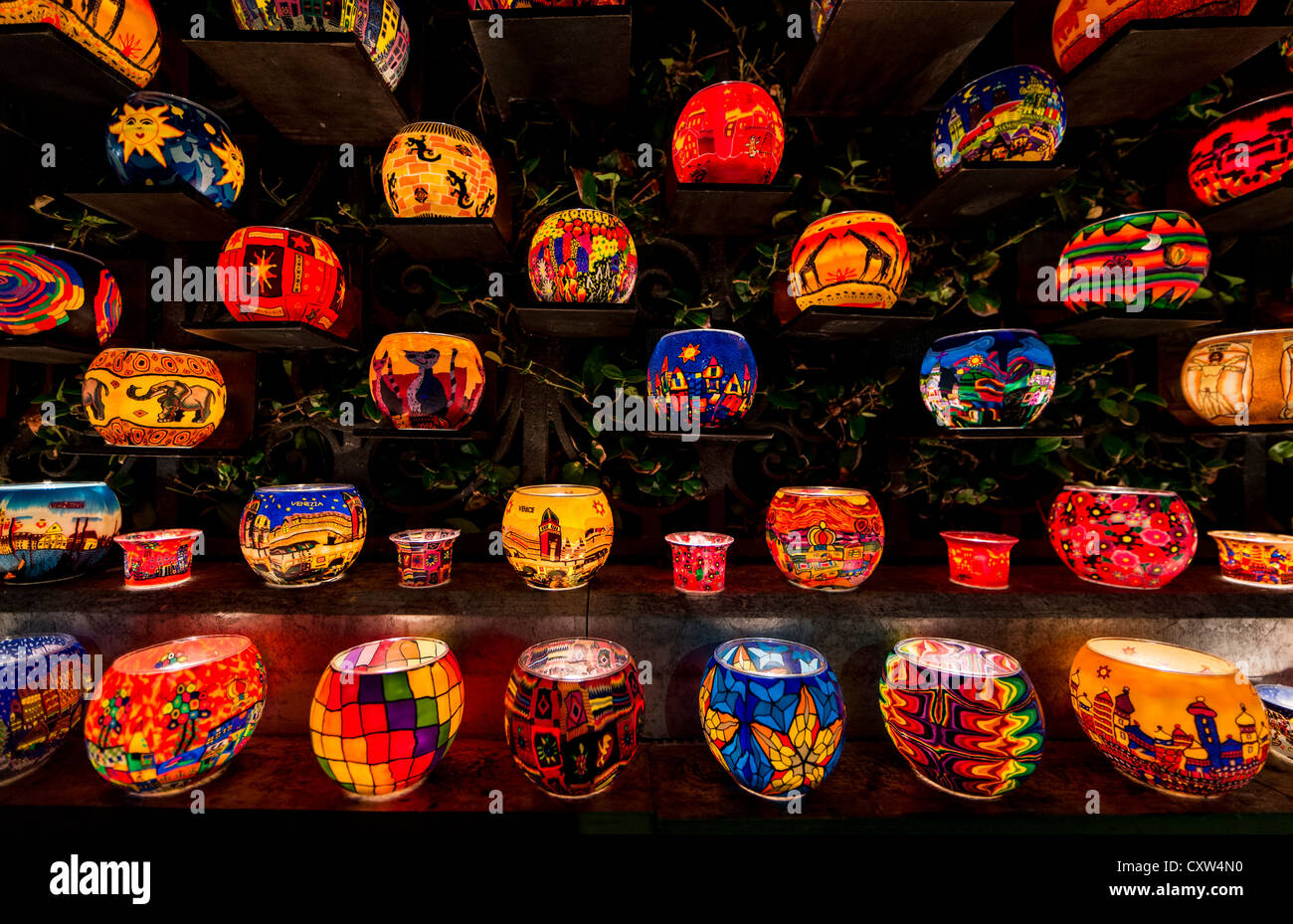 A street-vendor's display of coloured night-lights lit by burning ...