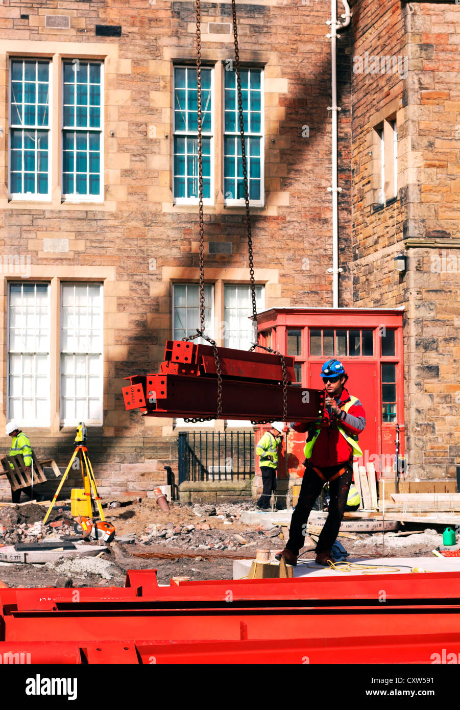 Workman moving steel into position via overhead crane Stock Photo - Alamy