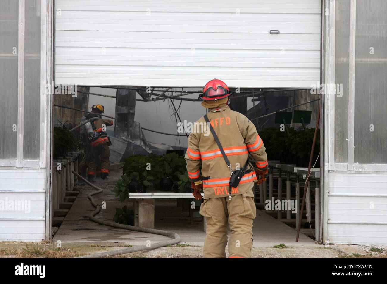 Firefighters investigating a fire in a greenhouse in Wisconsin Stock ...