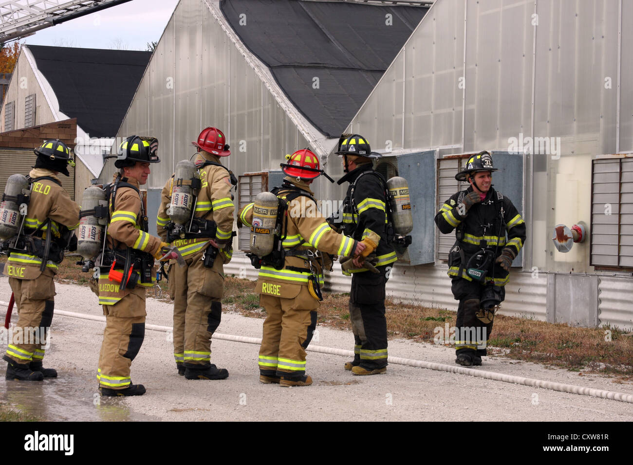 A group of firefighters waiting to attack a fire scene Stock Photo - Alamy