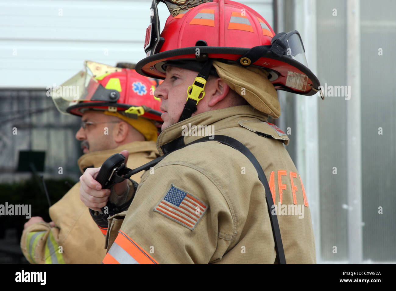 Two firefighters communicating at a fire scene at a greenhouse Stock ...