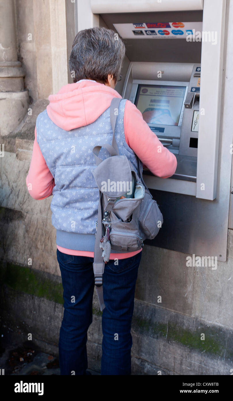Lady drawing money from High Street ATM machine Stock Photo - Alamy