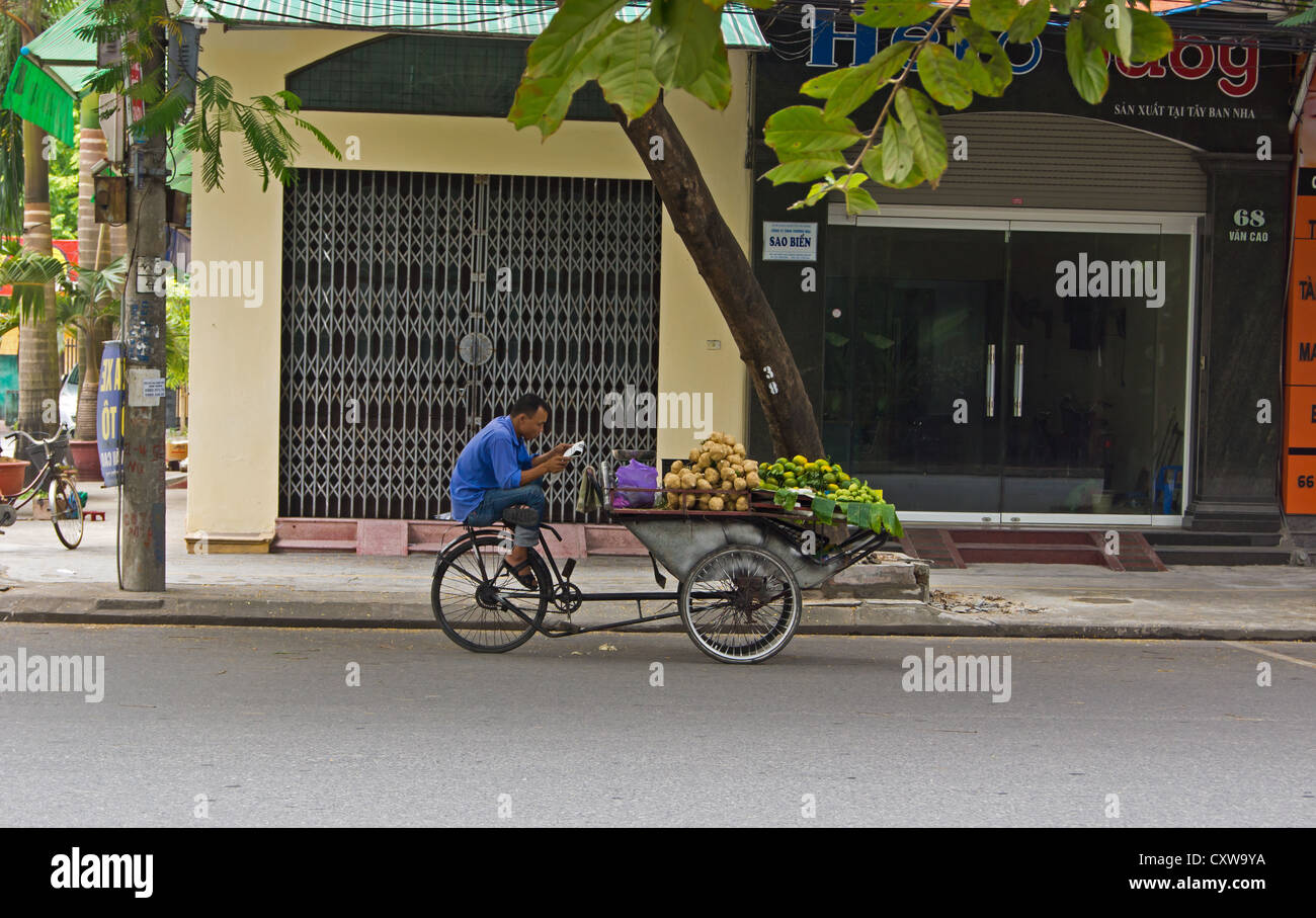 A turnip and fruits street seller sat at the side of the road on his ...
