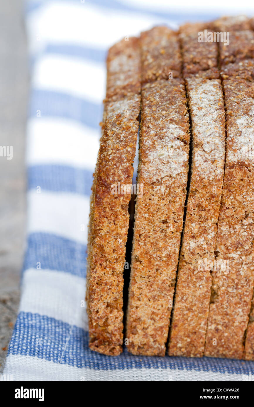 Slices of organic wholegrain dark rye bread, closeup on rustic wooden ...