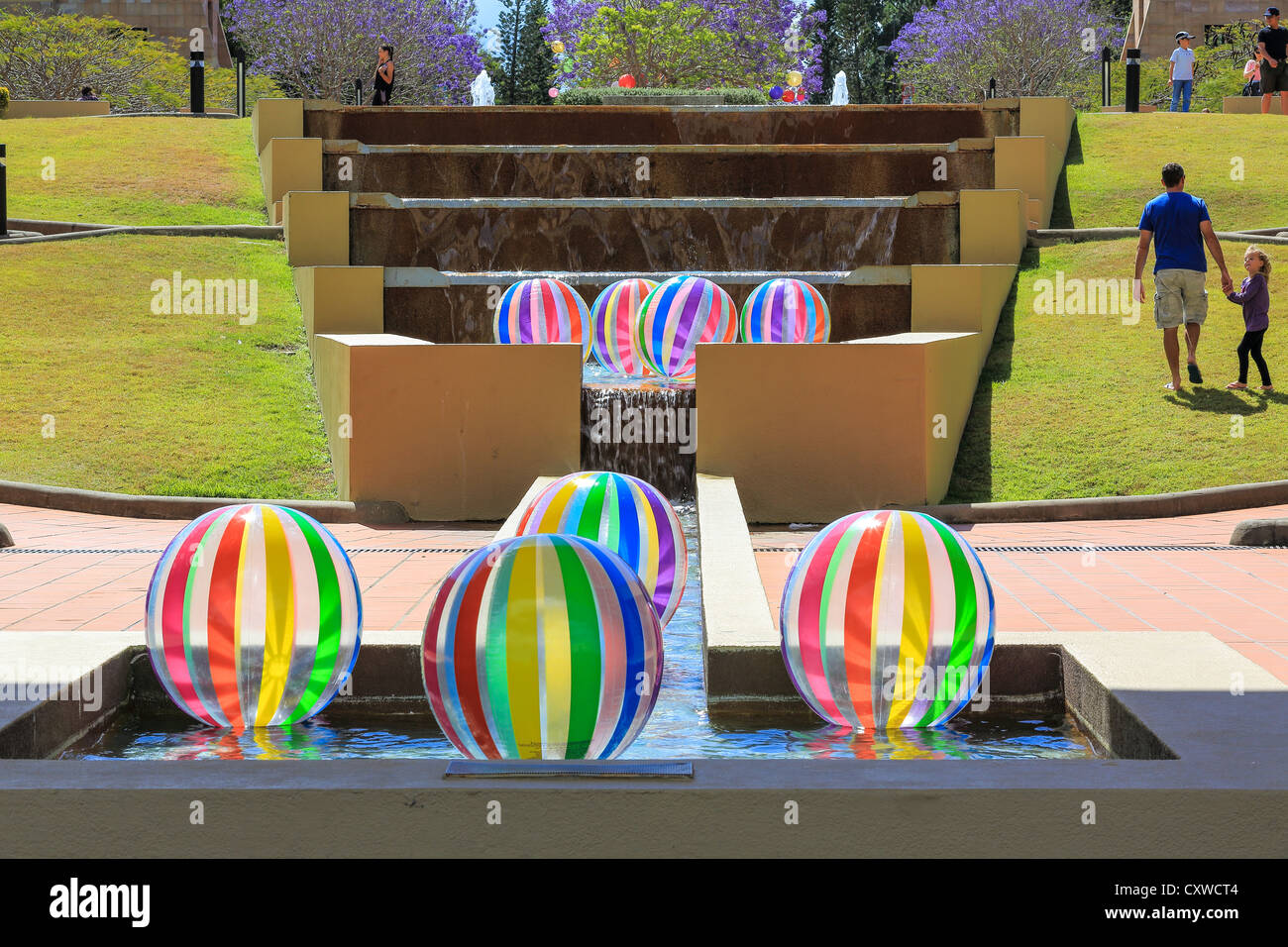 Colourful inflated transparent balls float in a man made pond in a pond ...