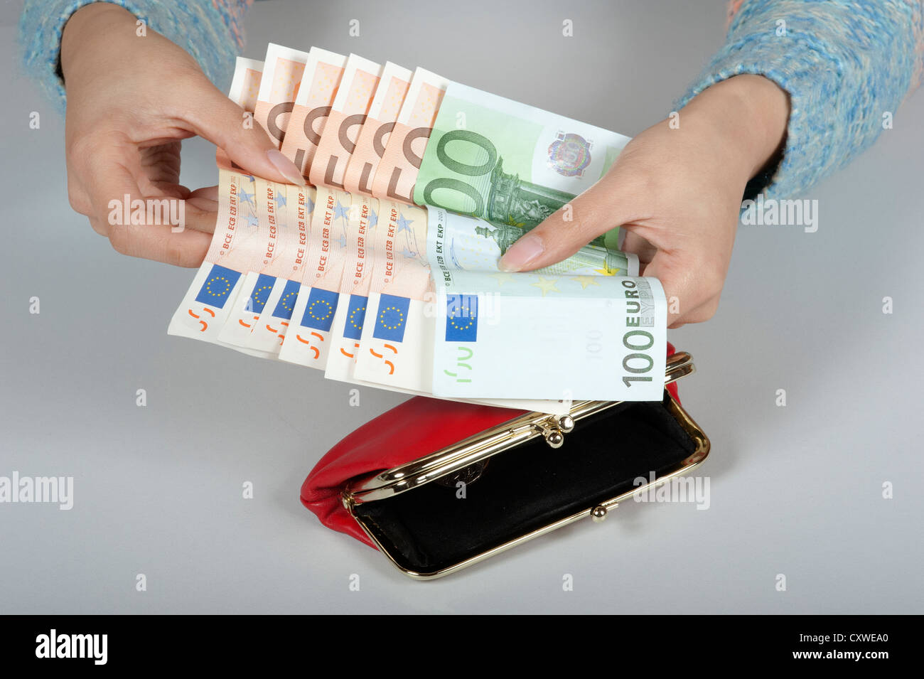 High denomination Euro banknotes in a woman's hand which is holding a ...