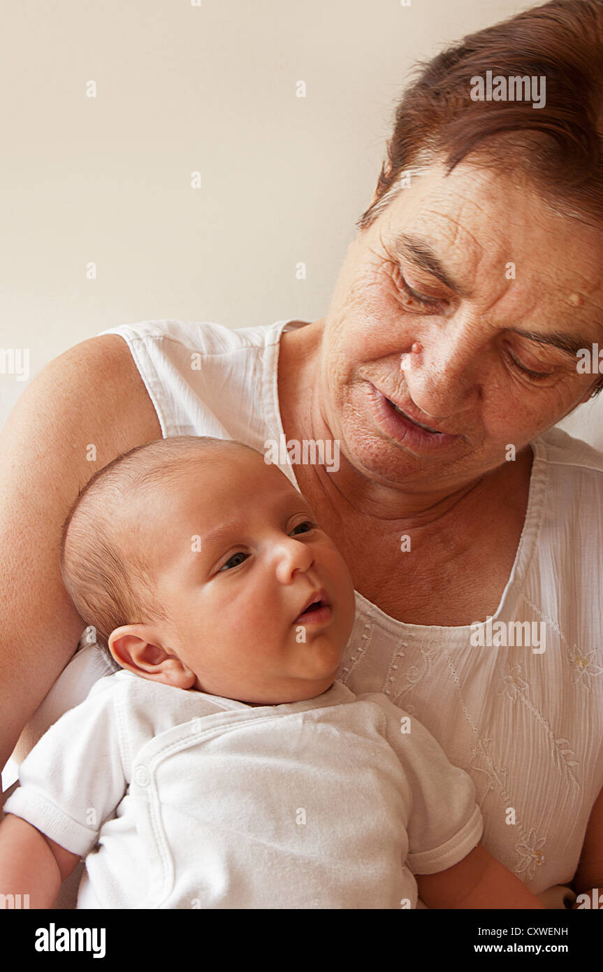 Senior Woman holding a baby boy in her hands Stock Photo - Alamy