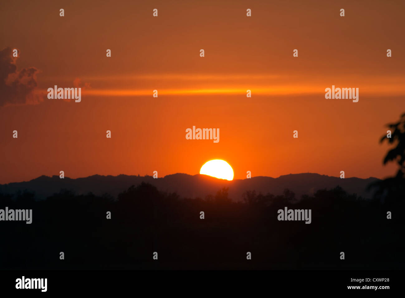 Orange sunset over the land and hills Stock Photo - Alamy