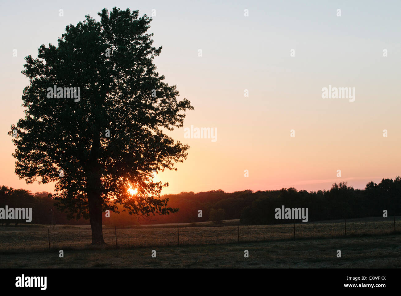 Sun setting over rural landscape Stock Photo - Alamy