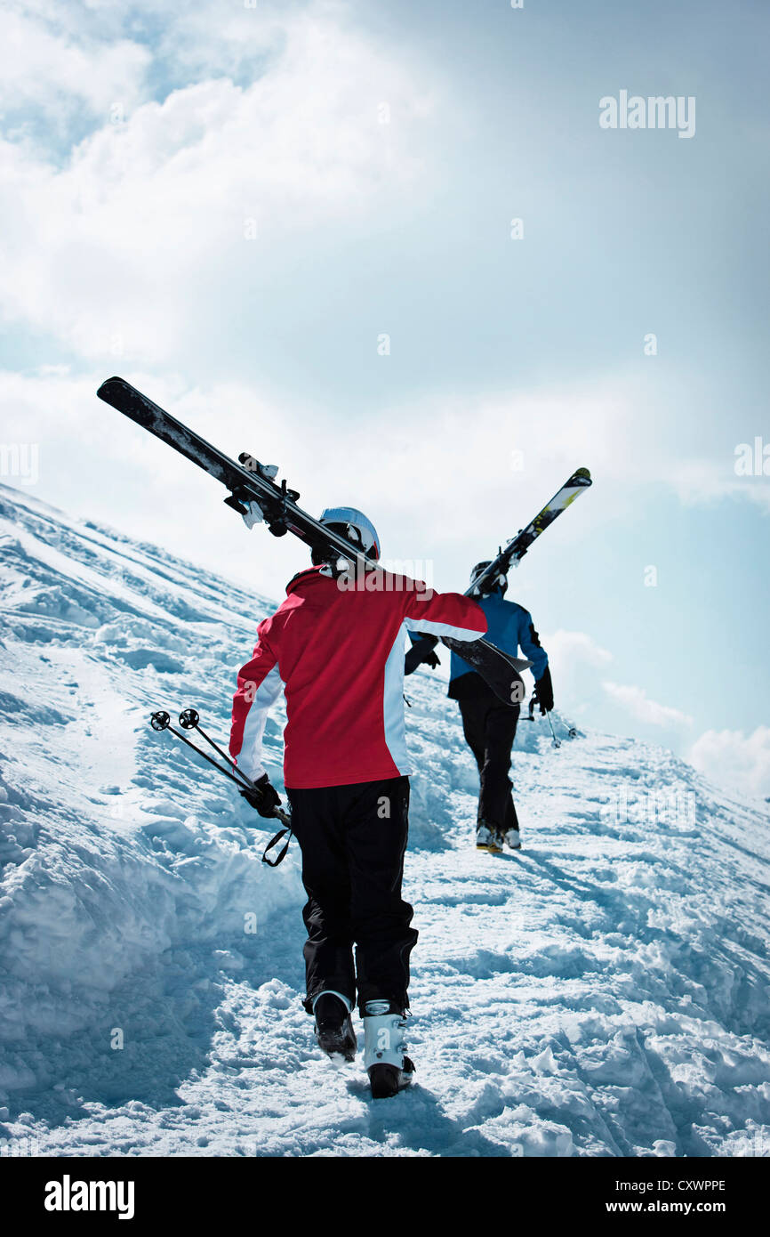 Skiers climbing up snowy mountainside Stock Photo - Alamy