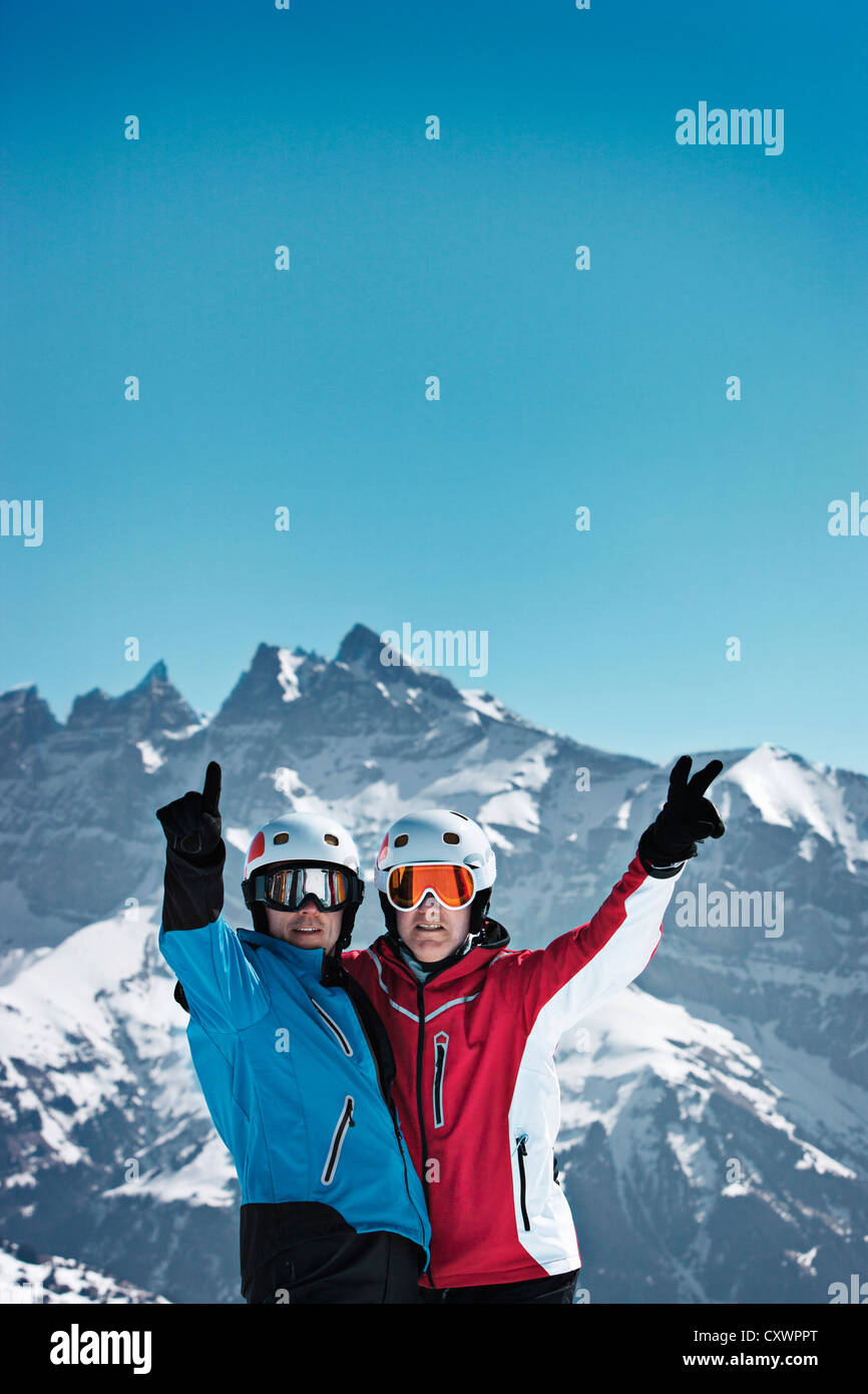 Skiers cheering on snowy mountain Stock Photo - Alamy
