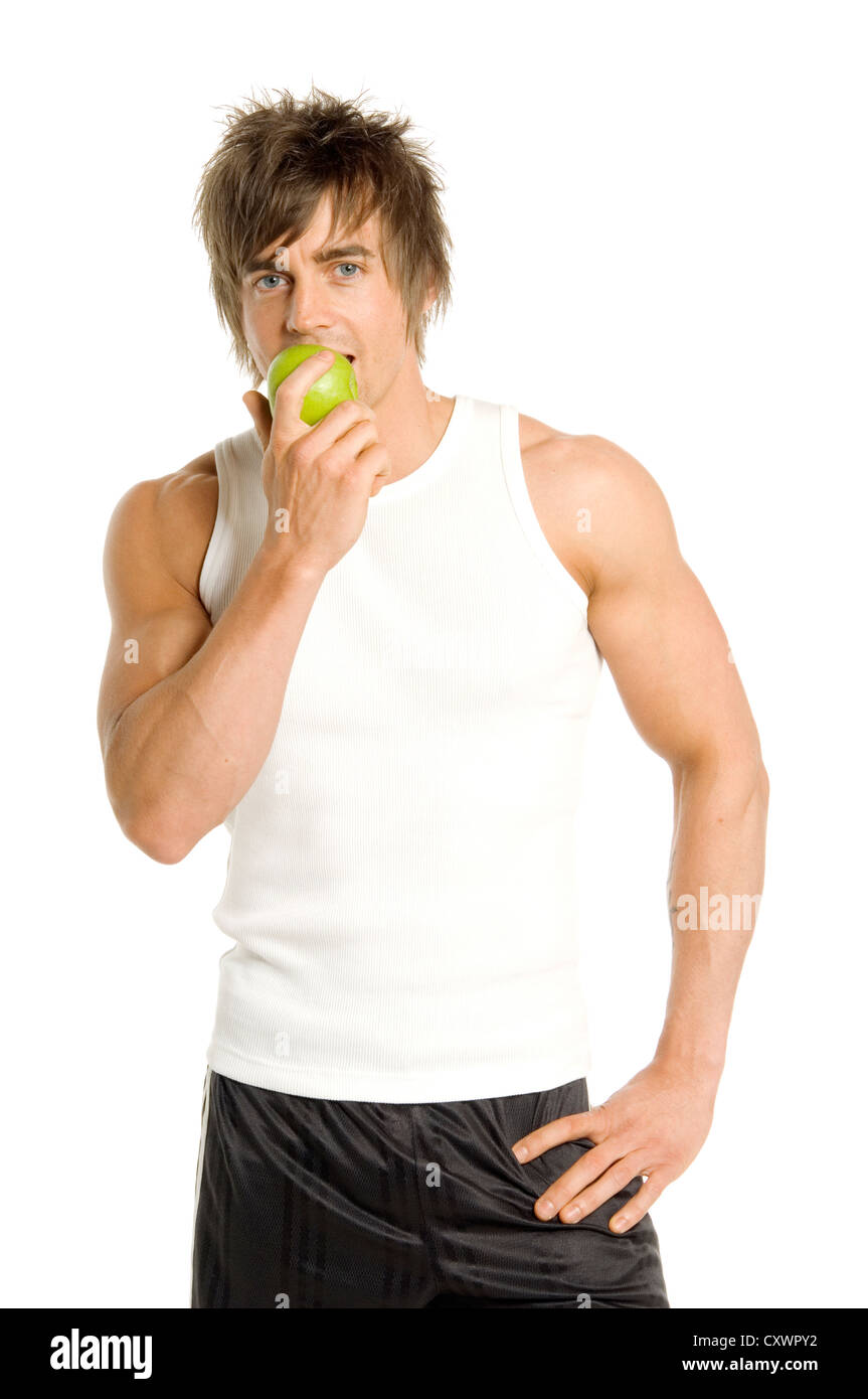Muscular man biting a green apple isolated on a white background Stock ...