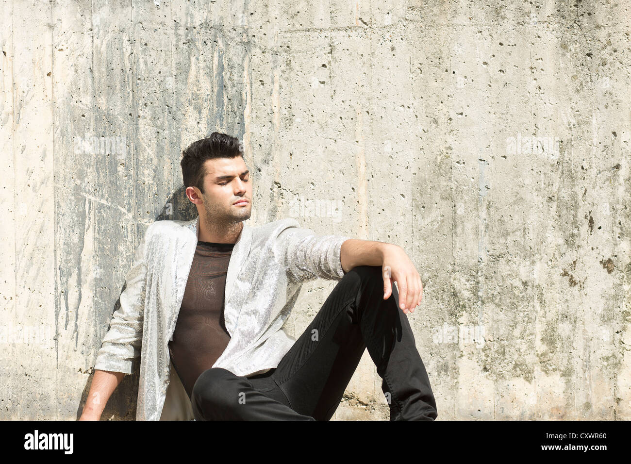 Man leaning against wall outdoors Stock Photo - Alamy