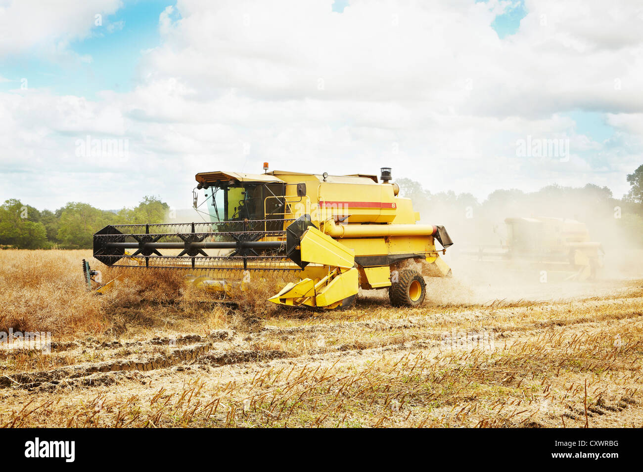 Thresher working in crop field Stock Photo - Alamy