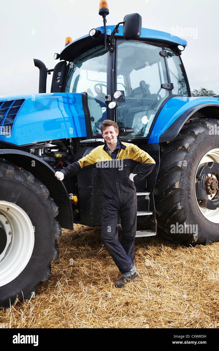 Farmer standing by tractor in field Stock Photo - Alamy