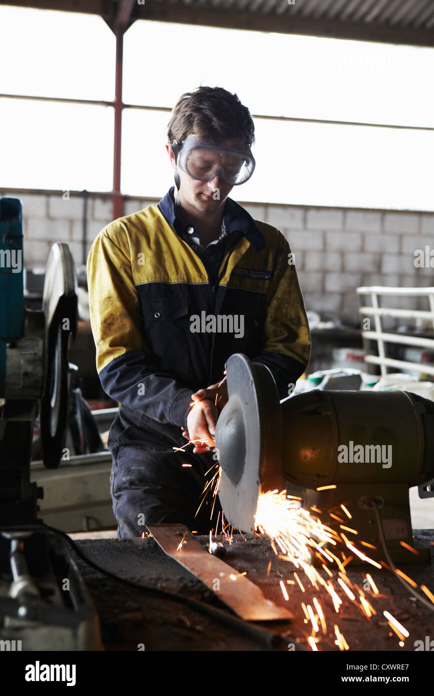 Metal worker using grinder in shop Stock Photo - Alamy